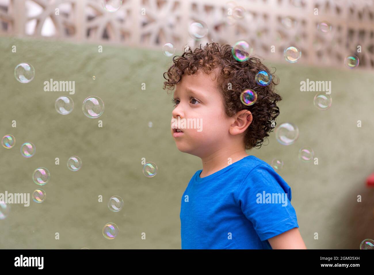 4 5 Year Old Caucasian Boy With Curly Hair In The Backyard Playing With 4-5-year-old-caucasian-boy-with-curly-hair-in-the-backyard-playing-with
