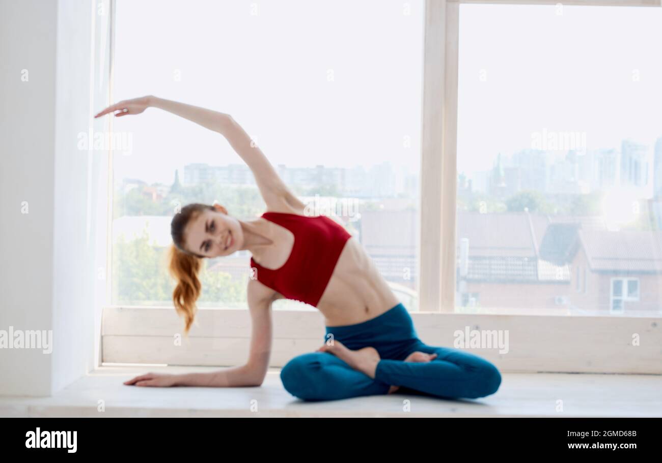 sportive woman doing yoga exercises near the window Stock Photo - Alamy