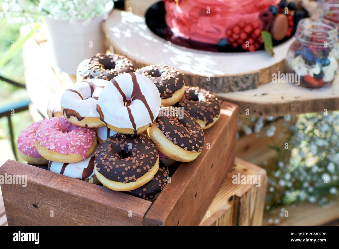 Mini donuts in a wooden box. Donuts in colored glaze Stock Photo - Alamy