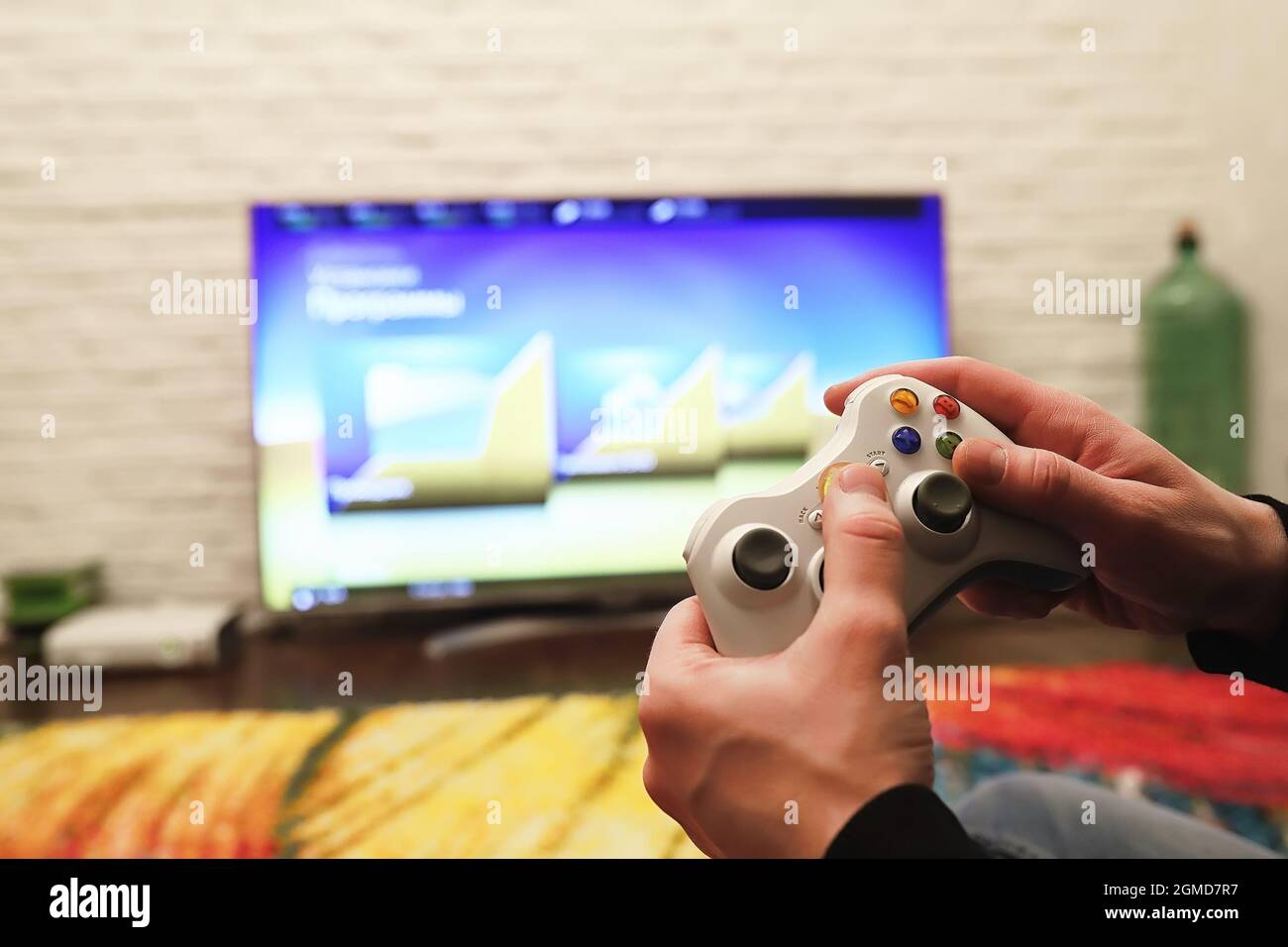 Playing on the console. Man is playing a game while lying on the floor ...