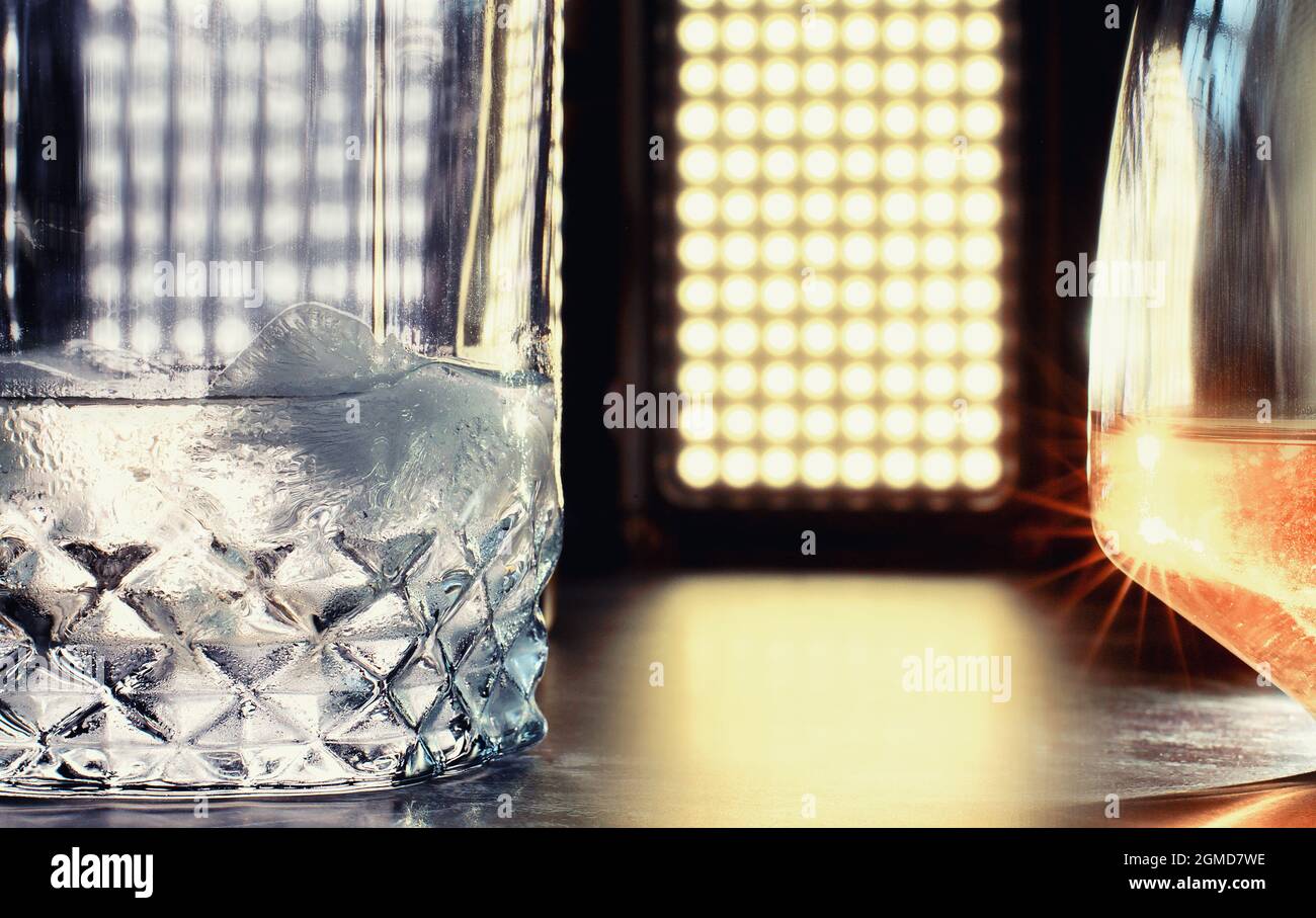 A glass of hard alcohol with ice on a bar counter. Whiskey with soda in ...