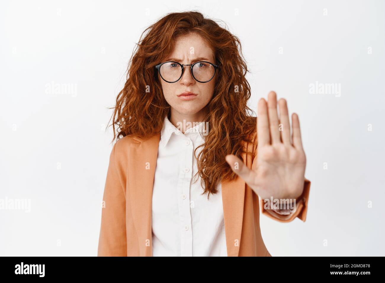 Angry redhead trainee, saleswoman showing stop, no gesture and frowning ...