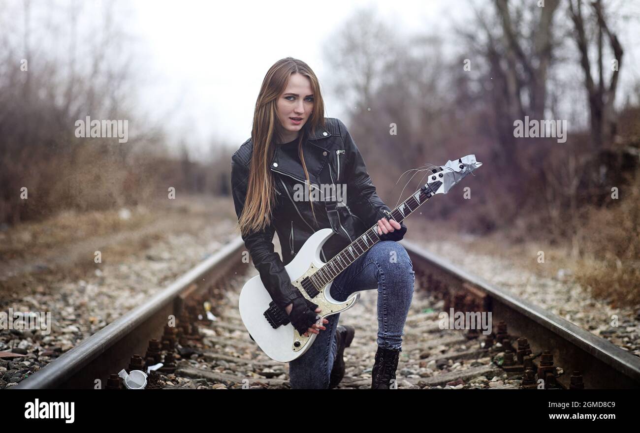 Beautiful young girl rocker with electric guitar. A rock musician girl ...