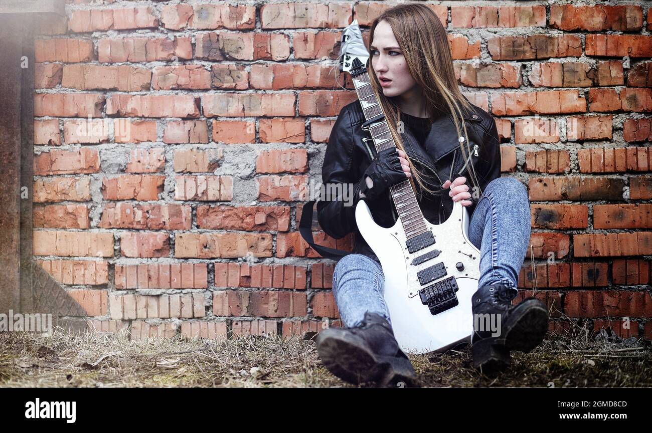 Beautiful young girl rocker with electric guitar. A rock musician girl ...