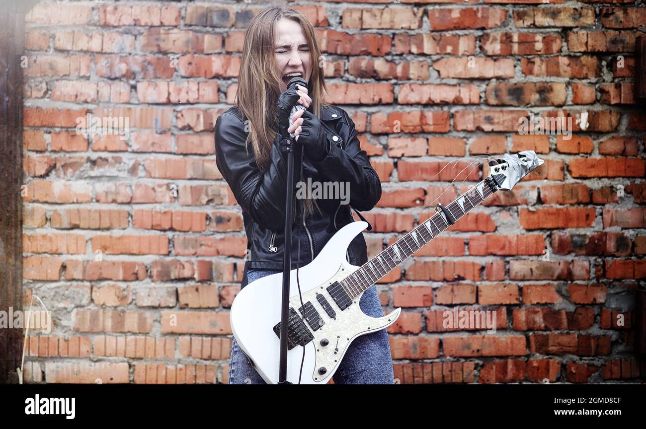 Beautiful young girl rocker with electric guitar. A rock musician girl ...