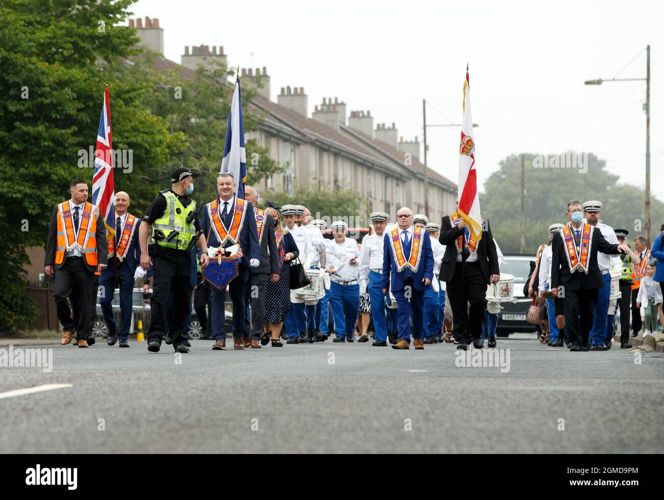 A silent Orange Order band marches through the streets of Easterhouse ...