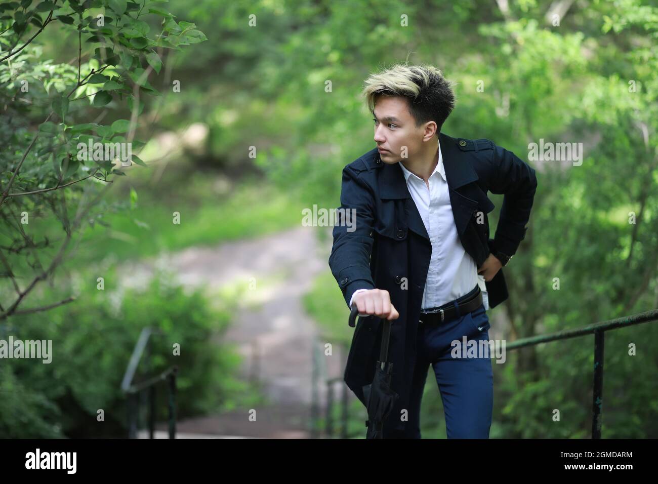 Spring Park in rainy weather and a young man with an umbrella Stock ...