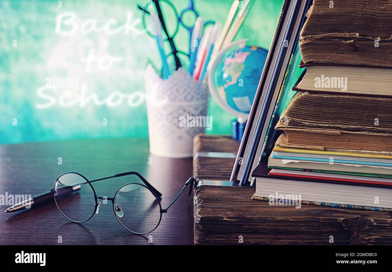 Education concept. A stack of textbooks and a book on the desk with ...