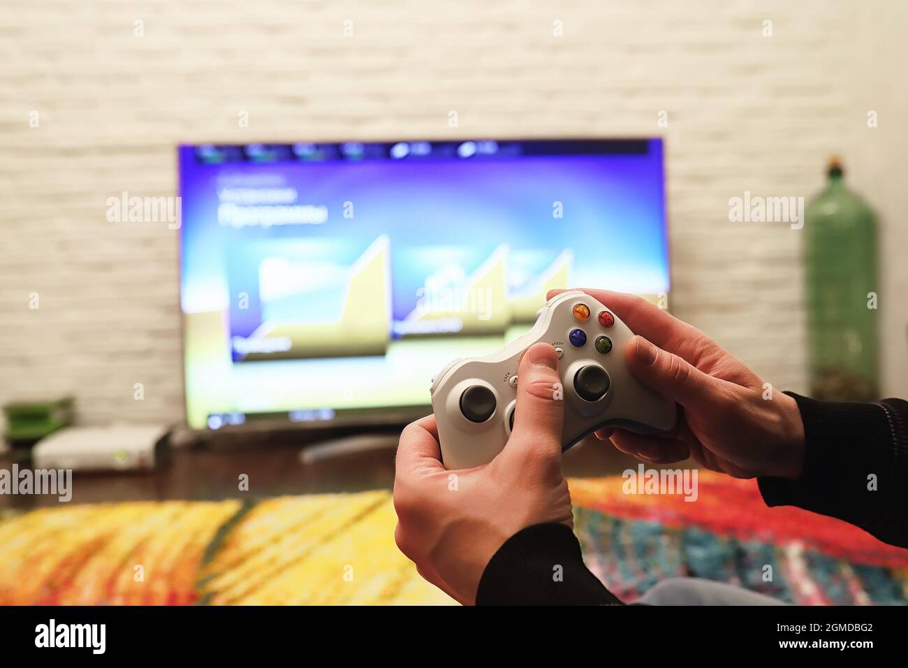 Playing on the console. Man is playing a game while lying on the floor ...