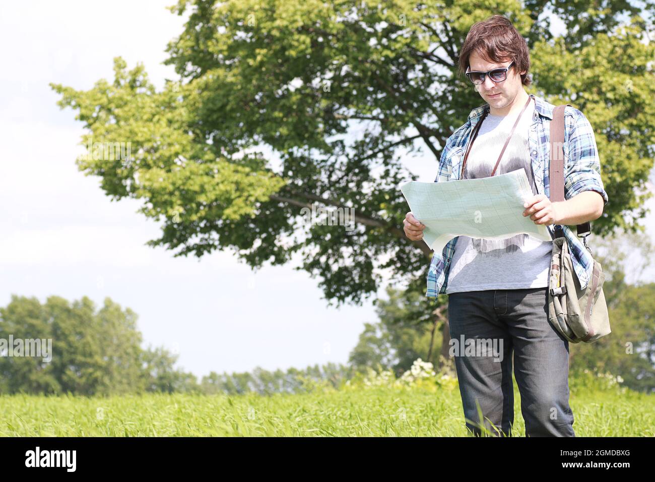 A young man looks at a map in the nature so as not to get lost Stock ...