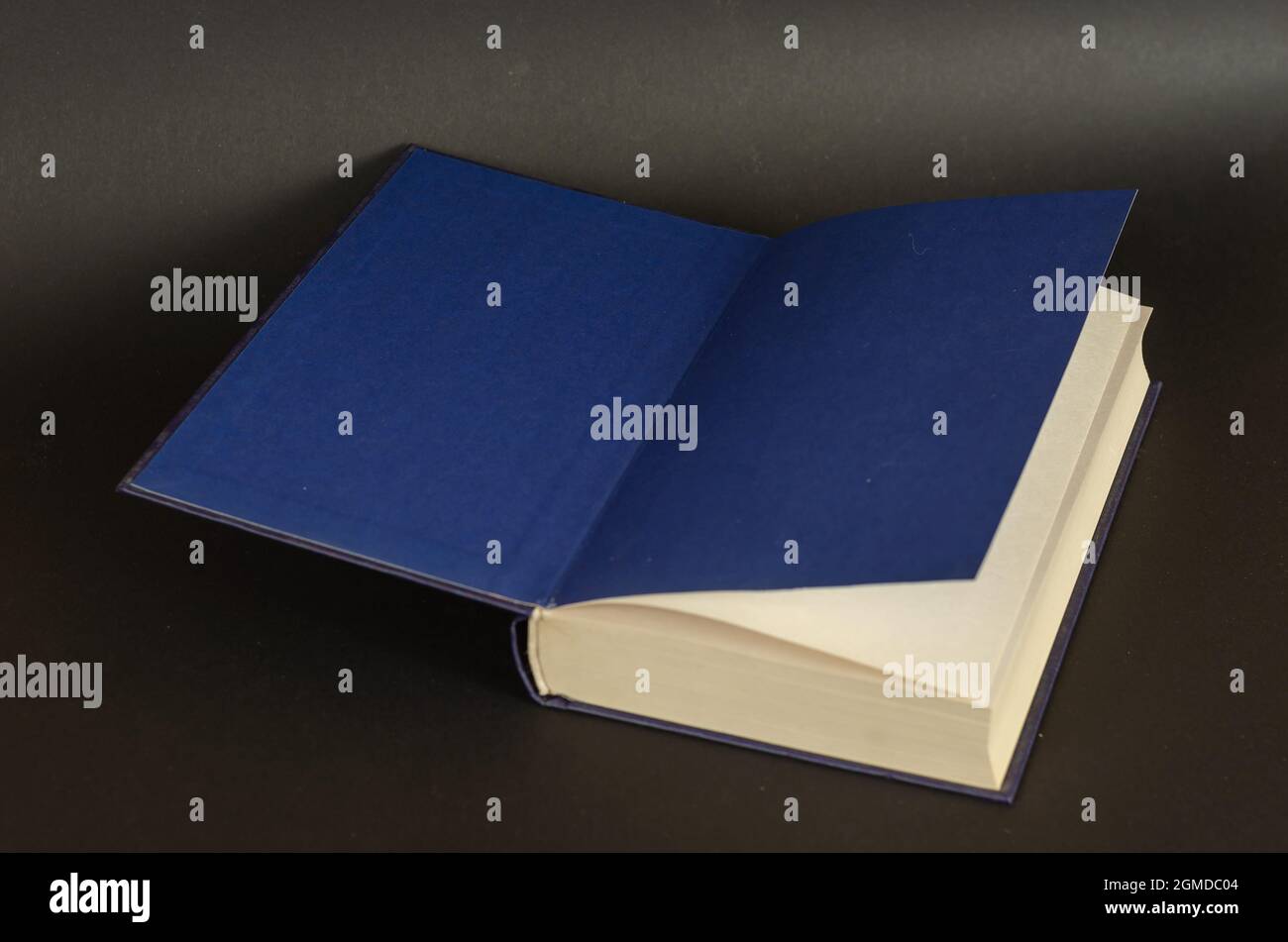 Open book on a black background. Textbook with blue endpapers. H Stock ...