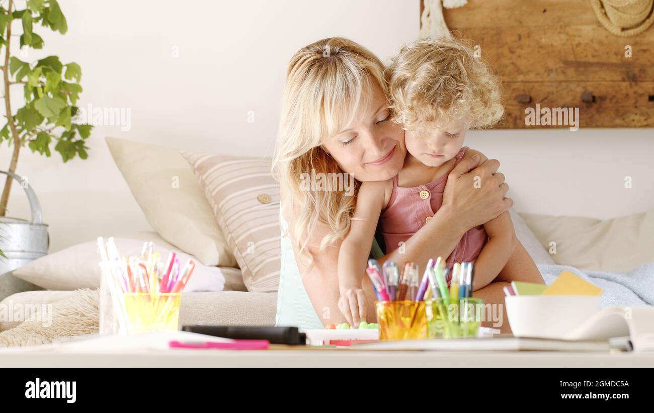 smiling mom hugs her daughter child, preschool learning activities at ...