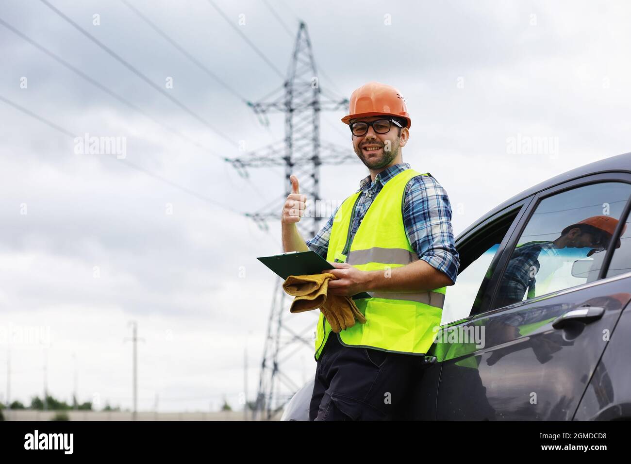 A man in a helmet and uniform, an electrician in the field ...