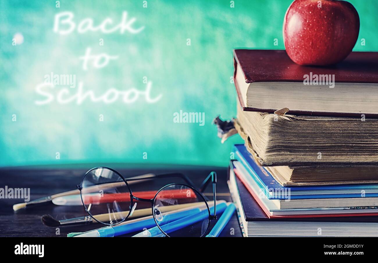 Education concept. A stack of textbooks and a book on the desk with ...