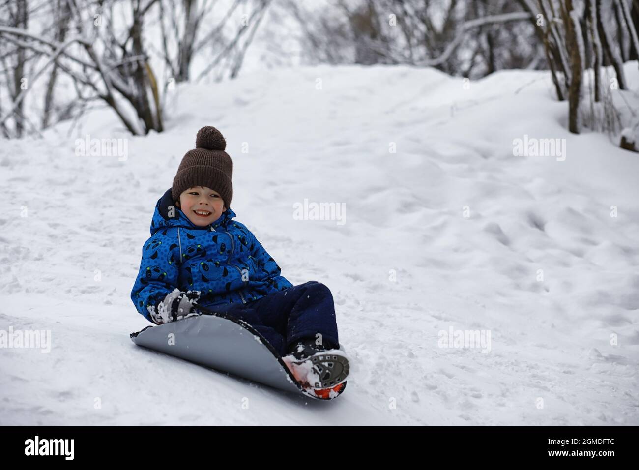 Children in the park in winter. Kids play with snow on playground. They ...