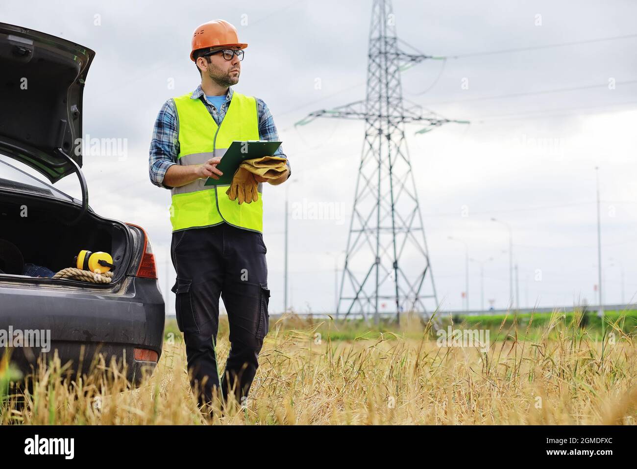 A man in a helmet and uniform, an electrician in the field ...