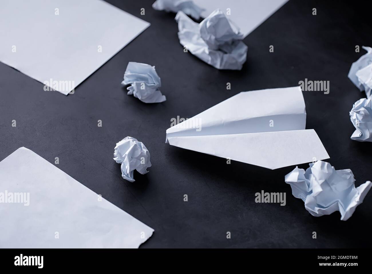Paper airplane on the table. Origami model on a dark background ...