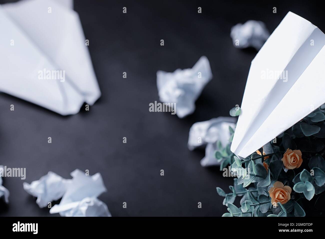 Paper airplane on the table. Origami model on a dark background ...