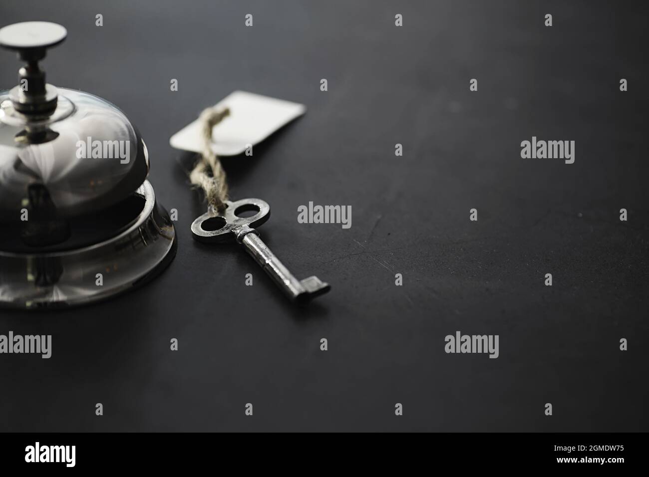 A shiny silver metal bell at hotel reception. A table in the hotel at ...