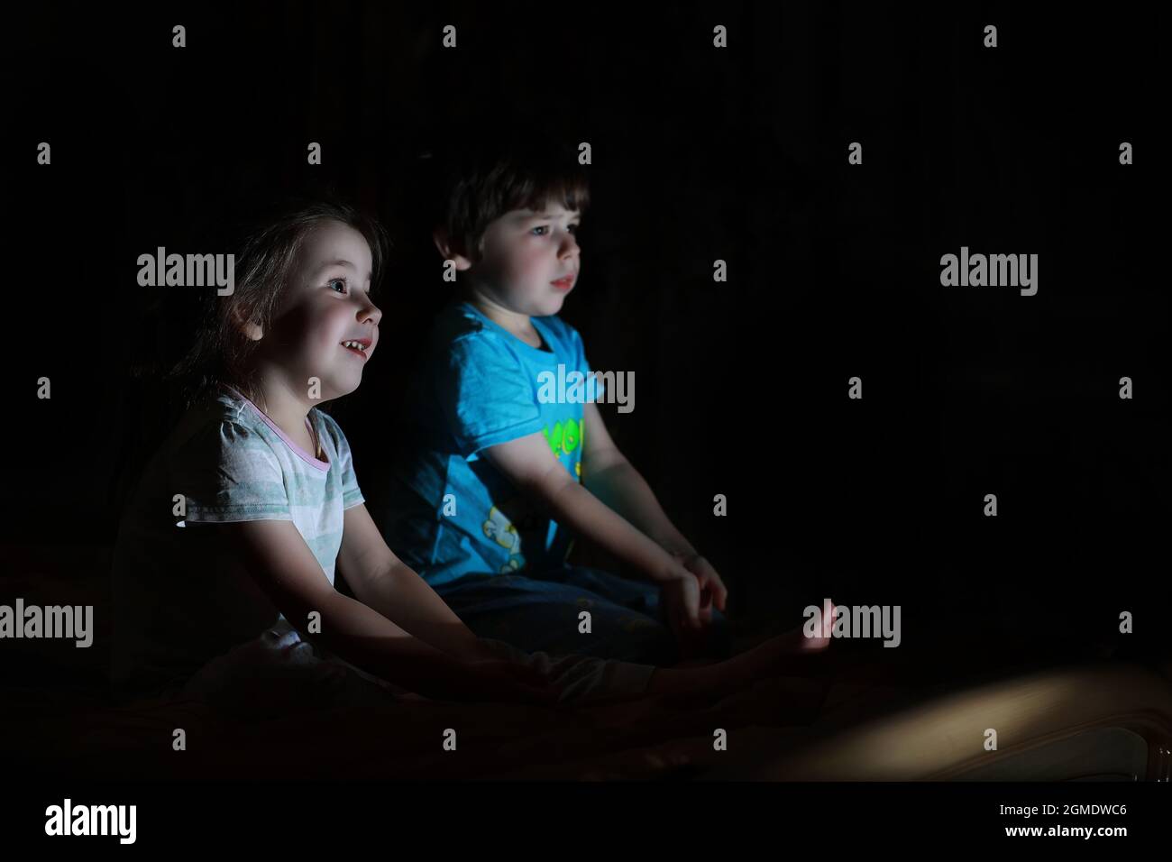Small children in a dark room watching TV at night Stock Photo - Alamy