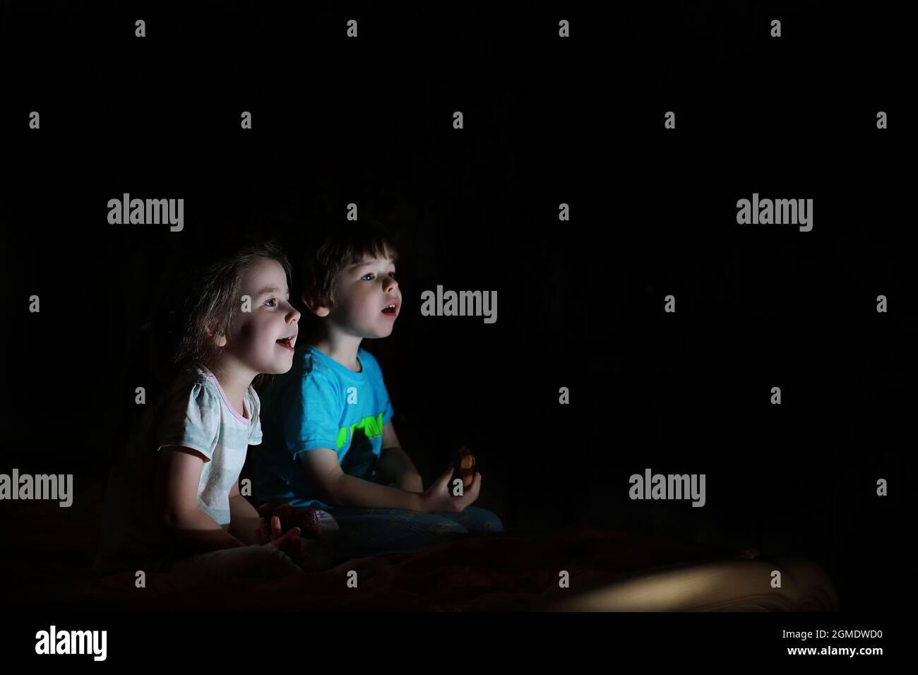 Small children in a dark room watching TV at night Stock Photo - Alamy