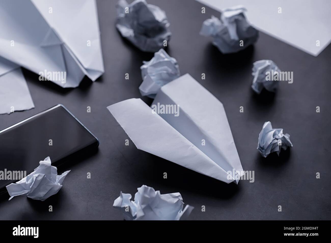 Paper airplane on the table. Origami model on a dark background ...