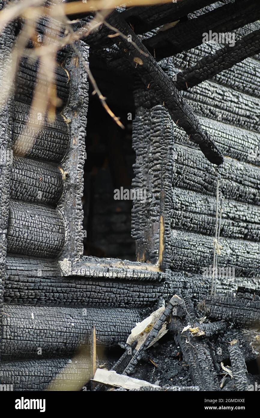 Wooden house after the fire. Coals on the logs. The ashes of the house ...