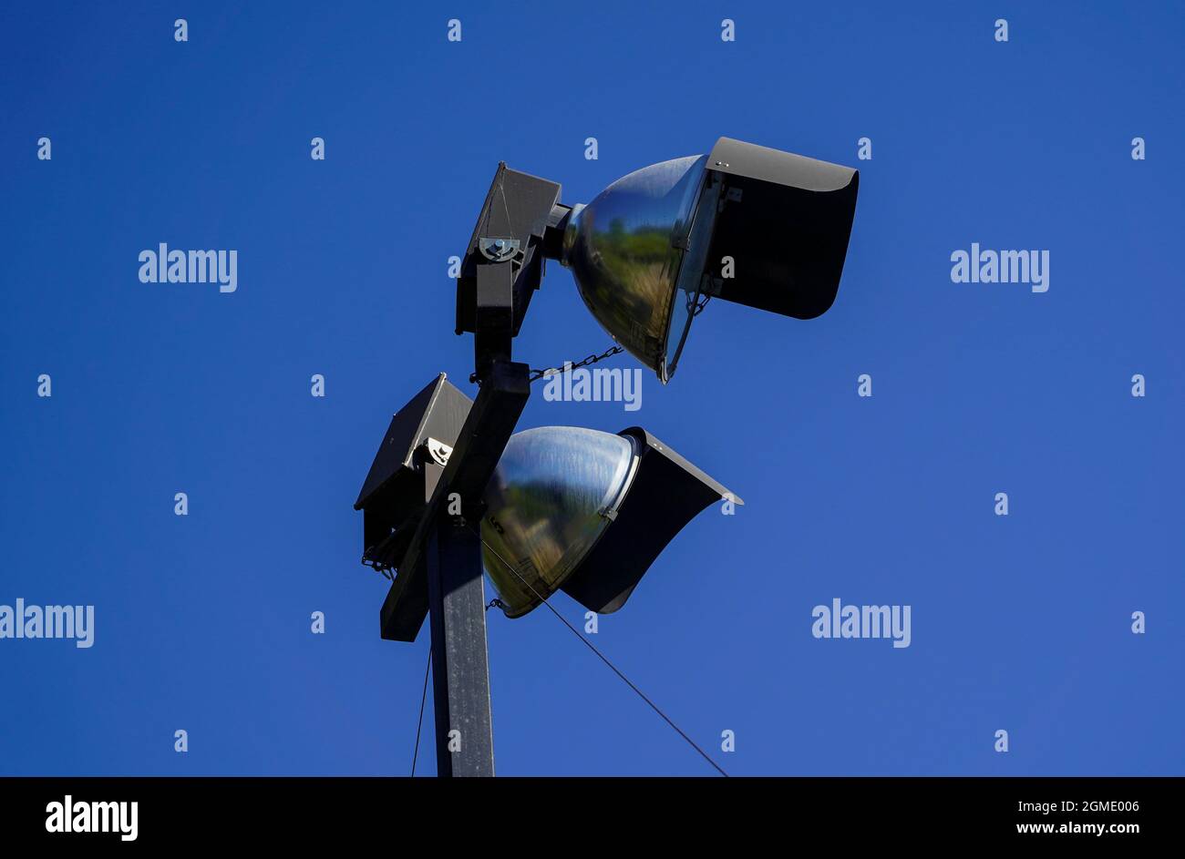Closeup of street projectors on a metal pole isolated on blue ...