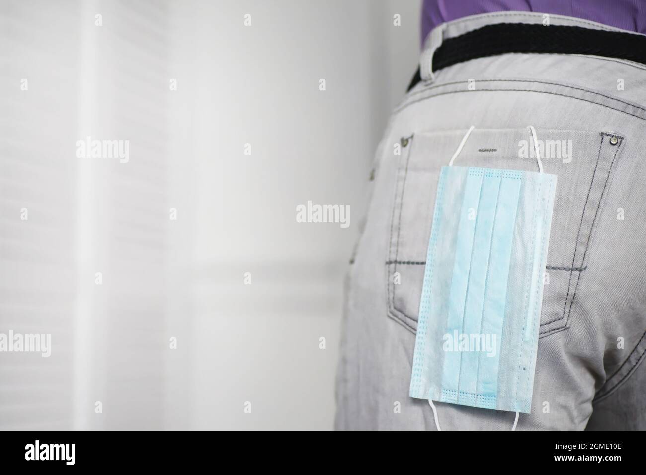 A disposable medical mask sticks out of a pocket instead napkin. A man ...