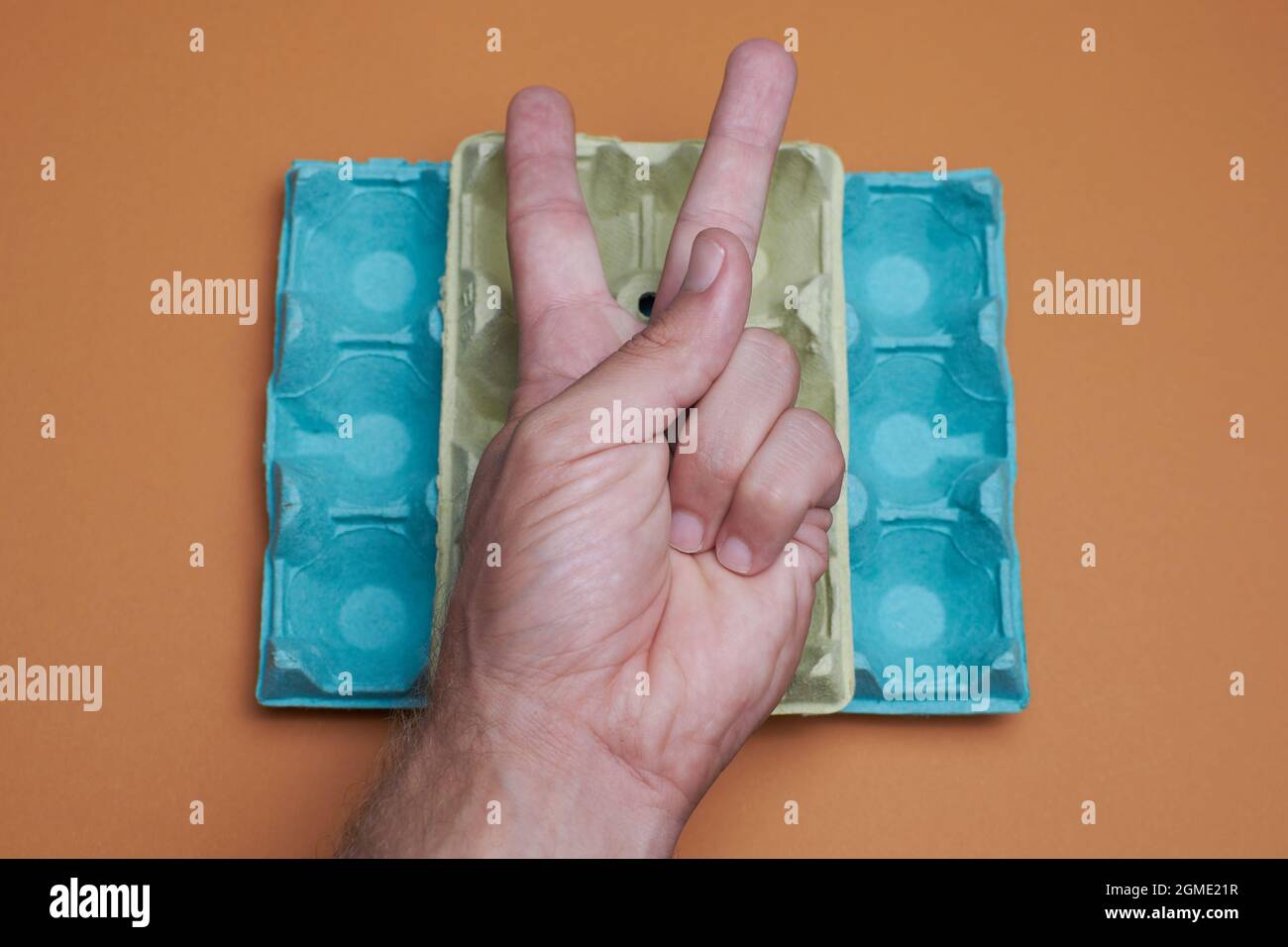 Hand peace greeting in orange background with egg carton Stock Photo ...