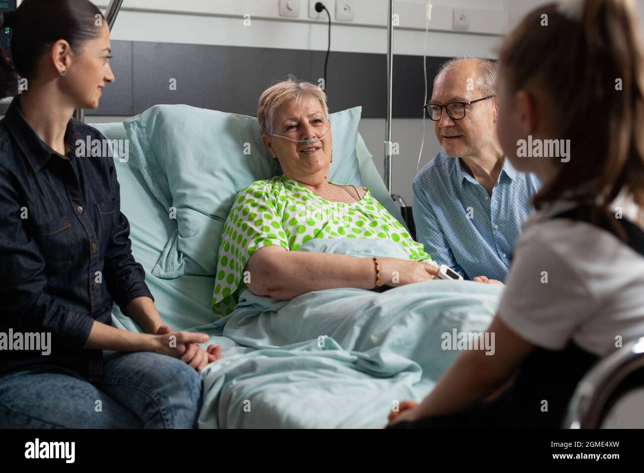 Sick retired grandmother talking with grandchild while resting in bed ...