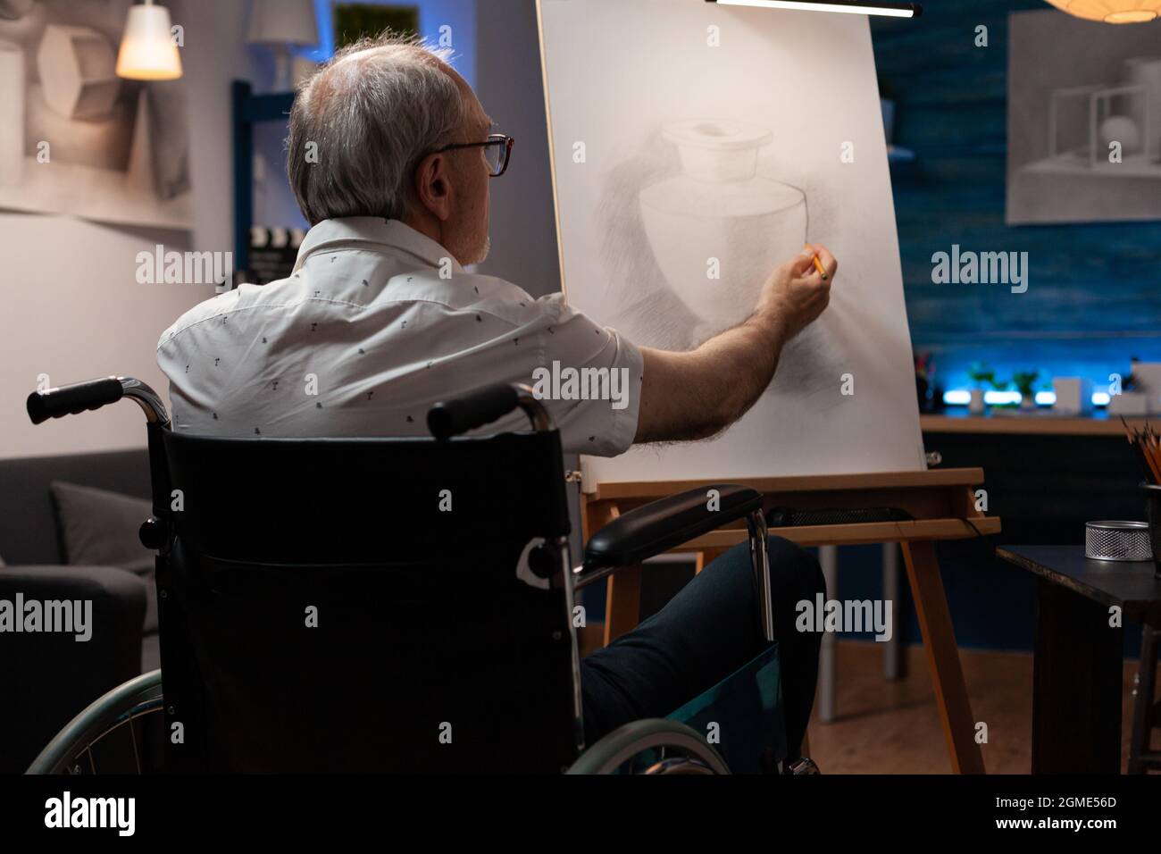 Senior artist with disability drawing vase design with pencil in ...
