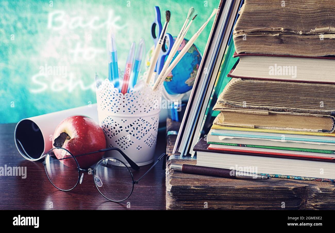 Education concept. A stack of textbooks and a book on the desk with ...