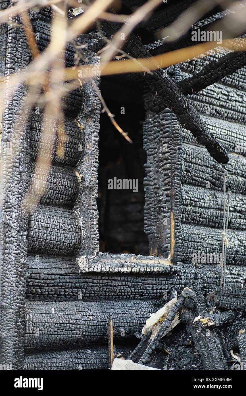 Wooden house after the fire. Coals on the logs. The ashes of the house ...