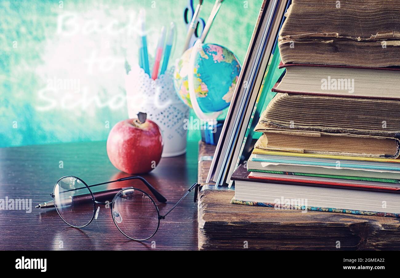 Education concept. A stack of textbooks and a book on the desk with ...