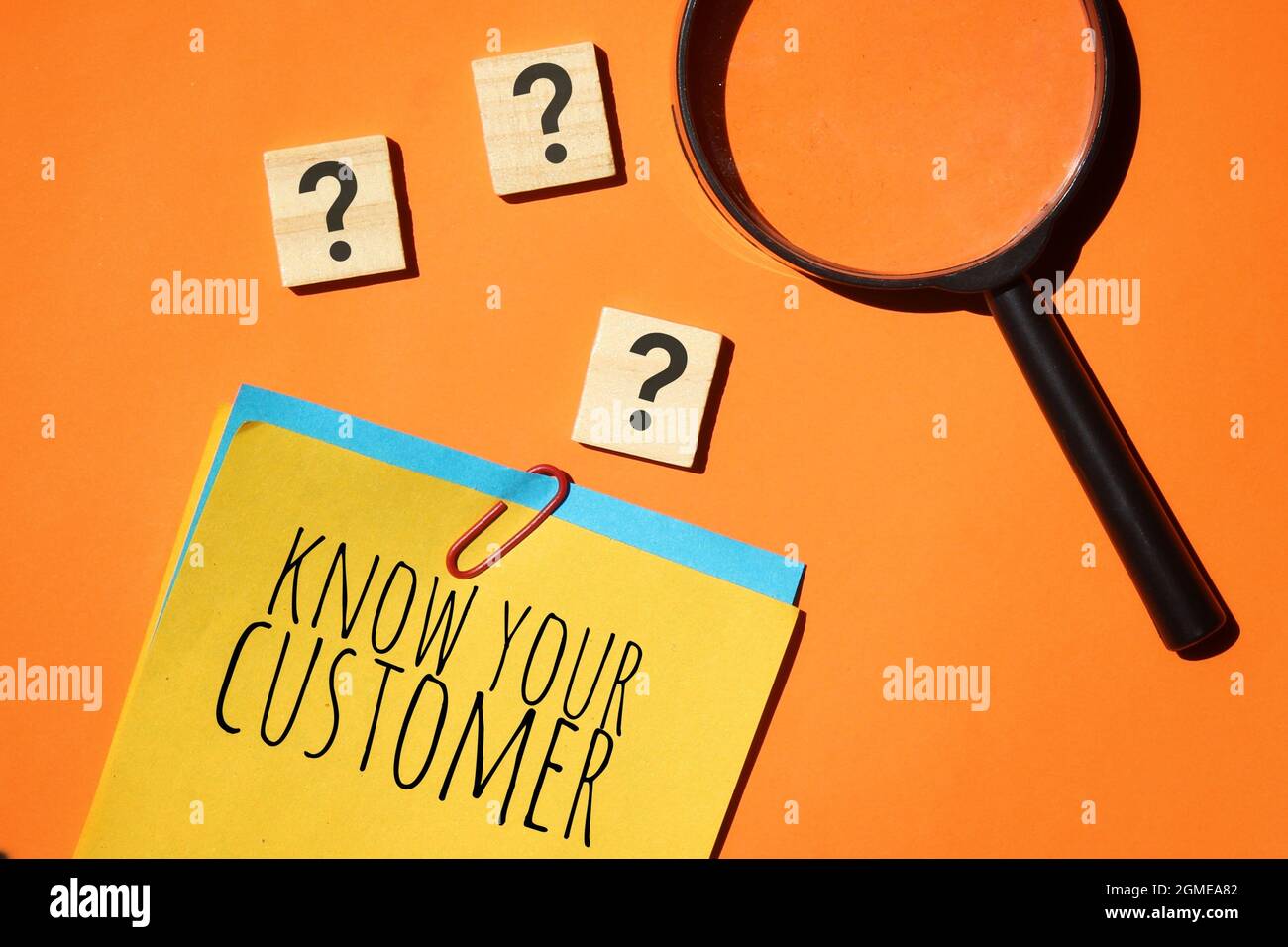 KNOW YOUR CUSTOMER text on color notepaper, wooden cube with question ...