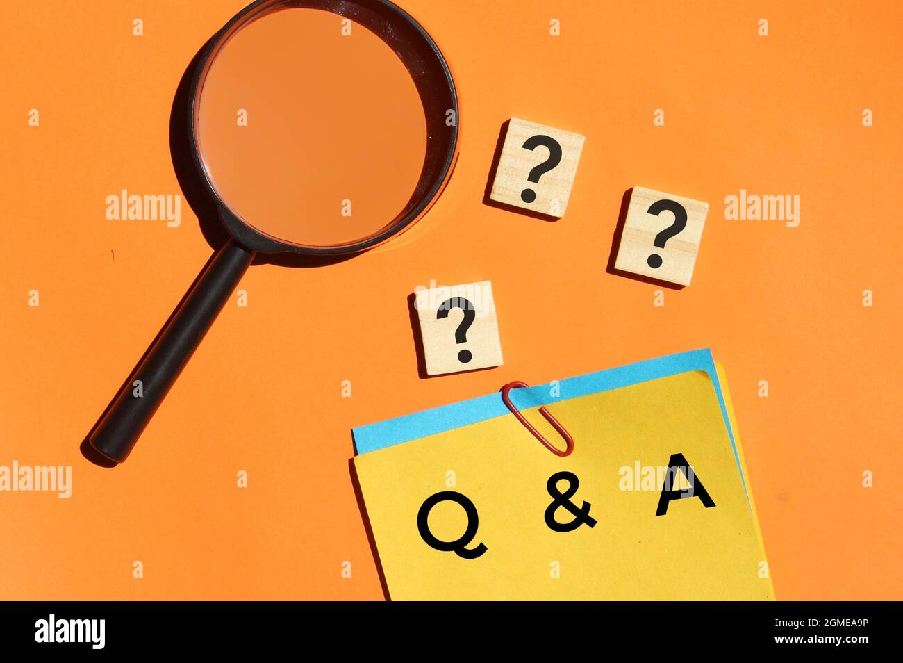 Top view of magnifying glass, wooden cube with question mark and color ...