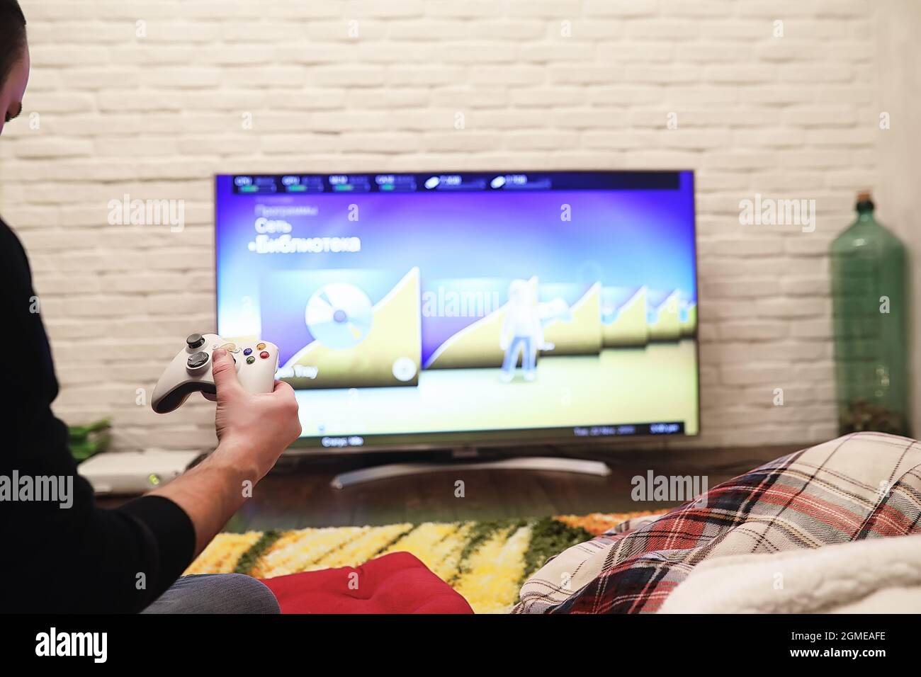 Playing on the console. Man is playing a game while lying on the floor ...