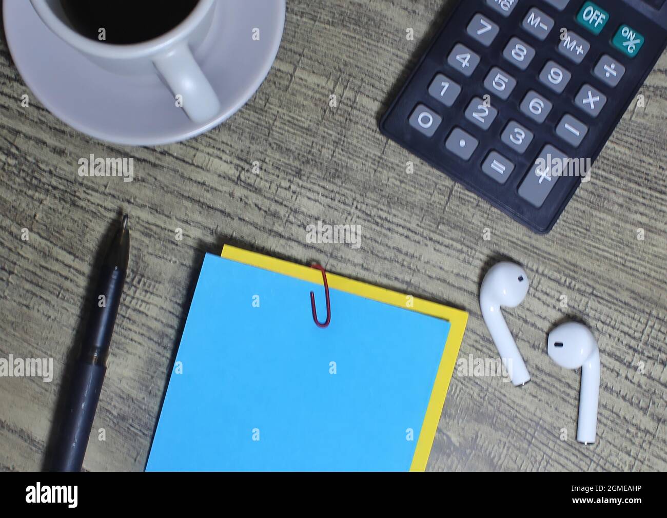Top view of wooden table with cup of coffee, calculator, pen and blank ...