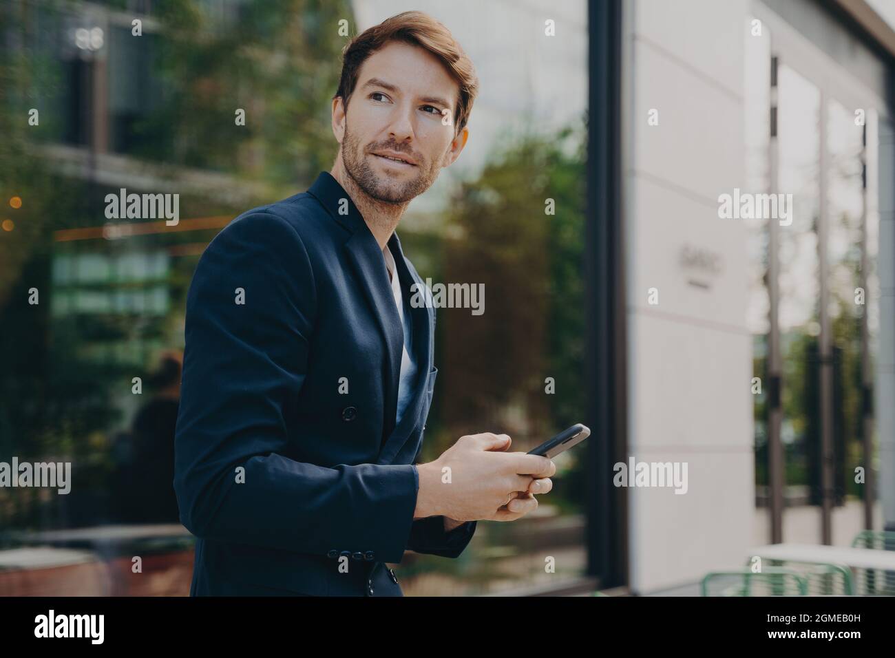 Pensive businessman holds cellular sends text messages dressed formally ... Pensive businessman holds cellular sends text messages dressed formally ...