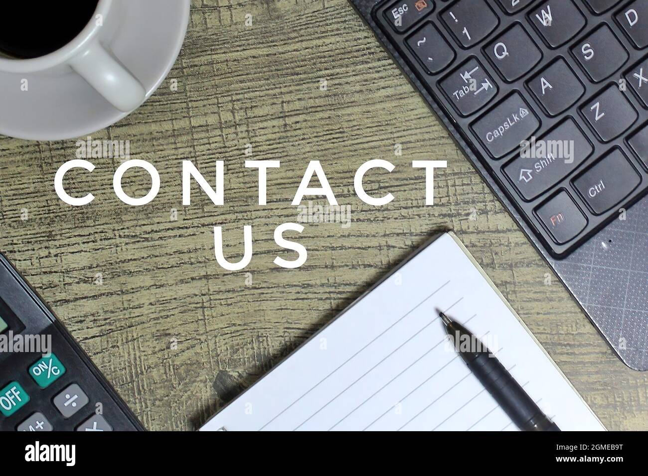 CONTACT US text surrounded by laptop, coffee, pen and paper Stock Photo ...