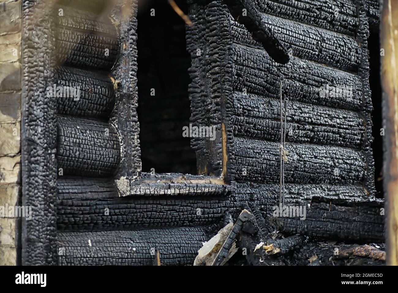 Wooden house after the fire. Coals on the logs. The ashes of the house ...