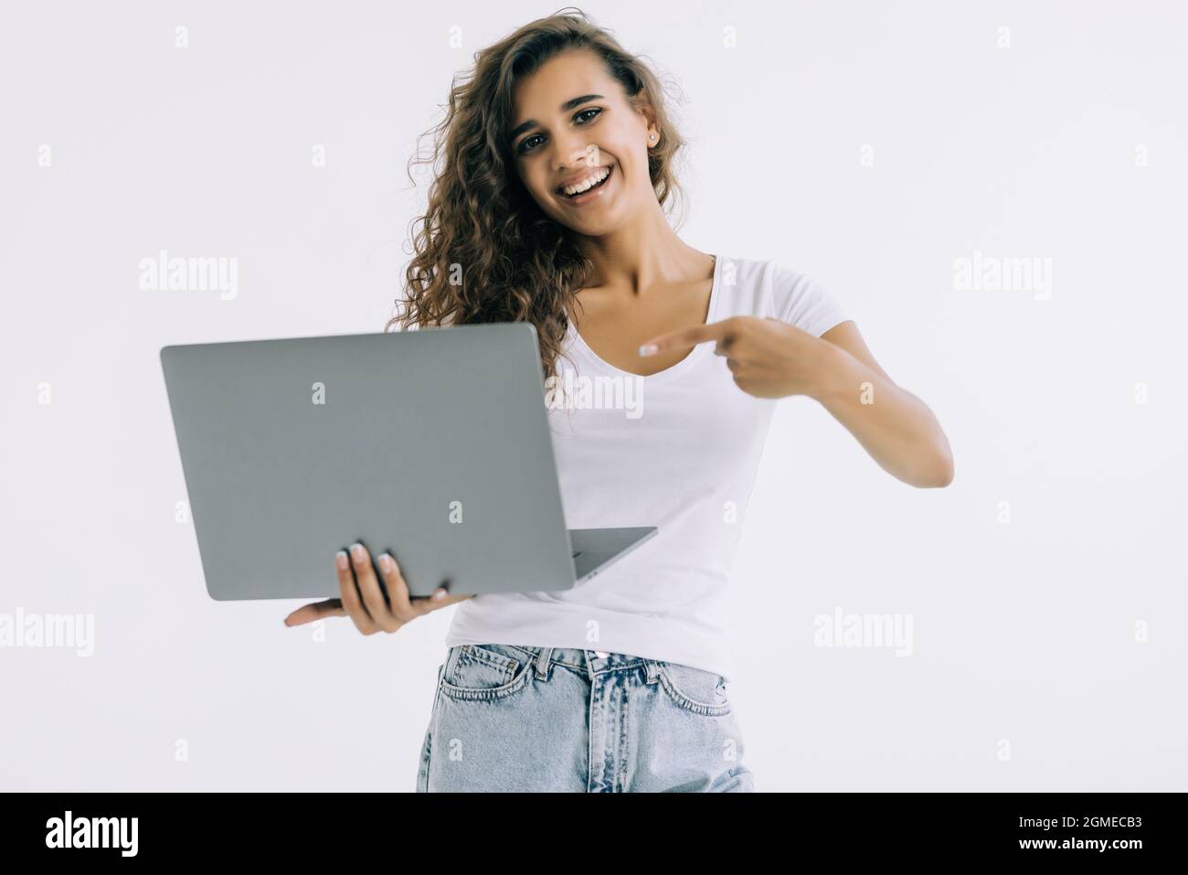 Happy woman pointing at a laptop computer screen isolated over white ...