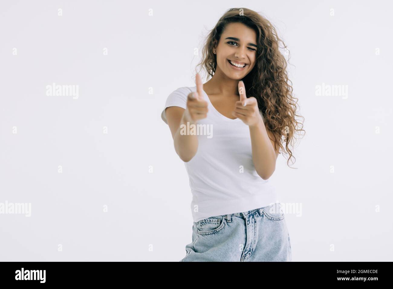 Portrait of a beautiful young woman pointing at you, isolated on white ...
