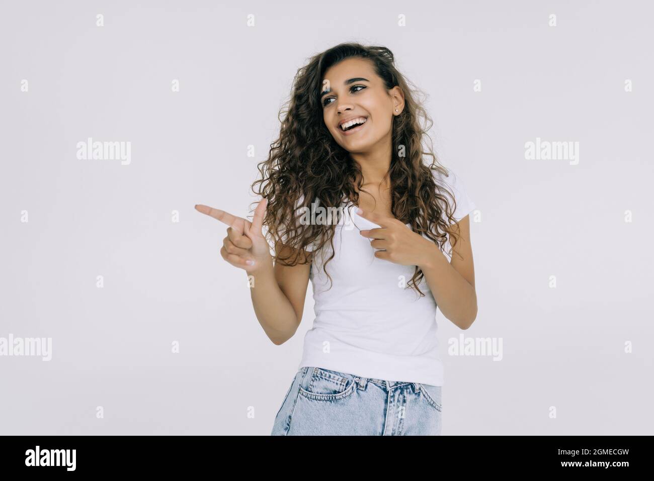 Happy woman pointing to the side over a white background Stock Photo ...