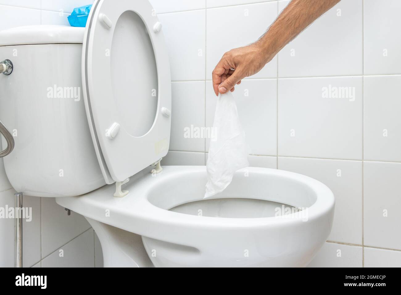Hand throwing wet wipe into toilet Stock Photo - Alamy