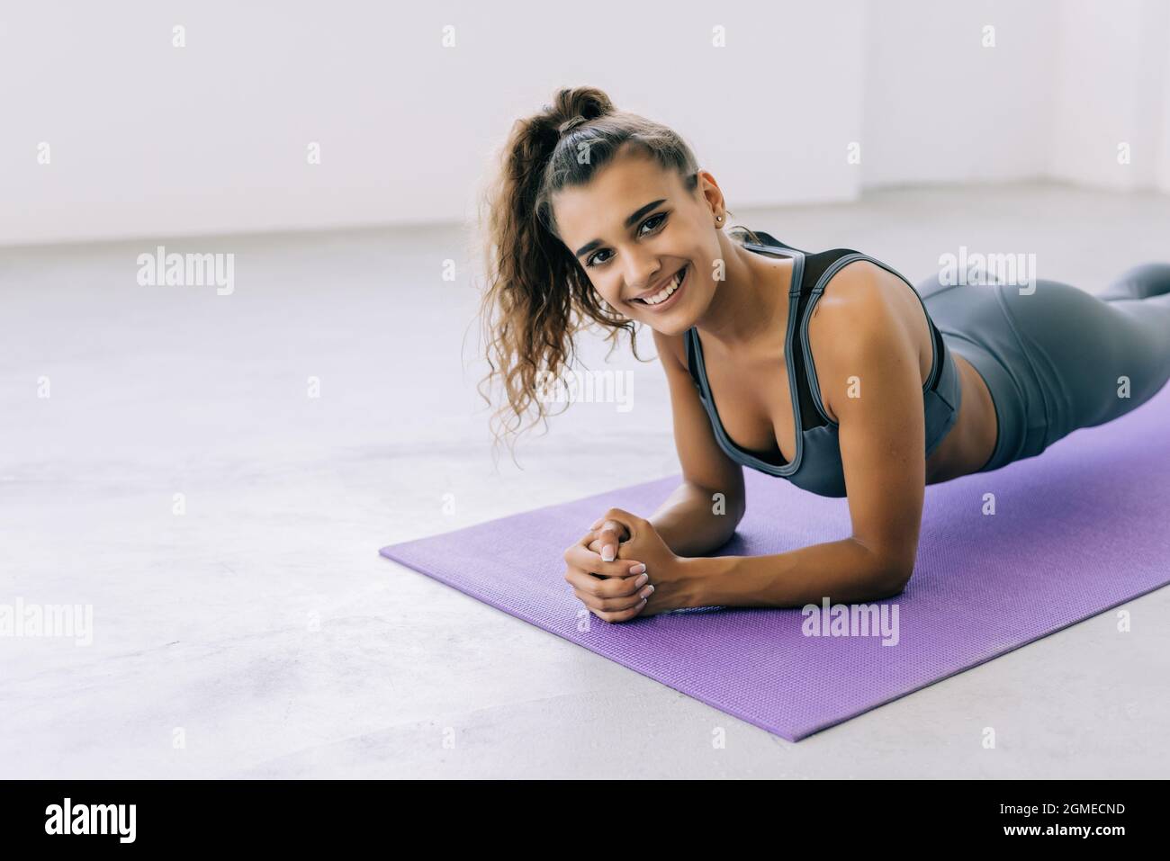 Perfect plank. Full-length side view of young beautiful woman in ...