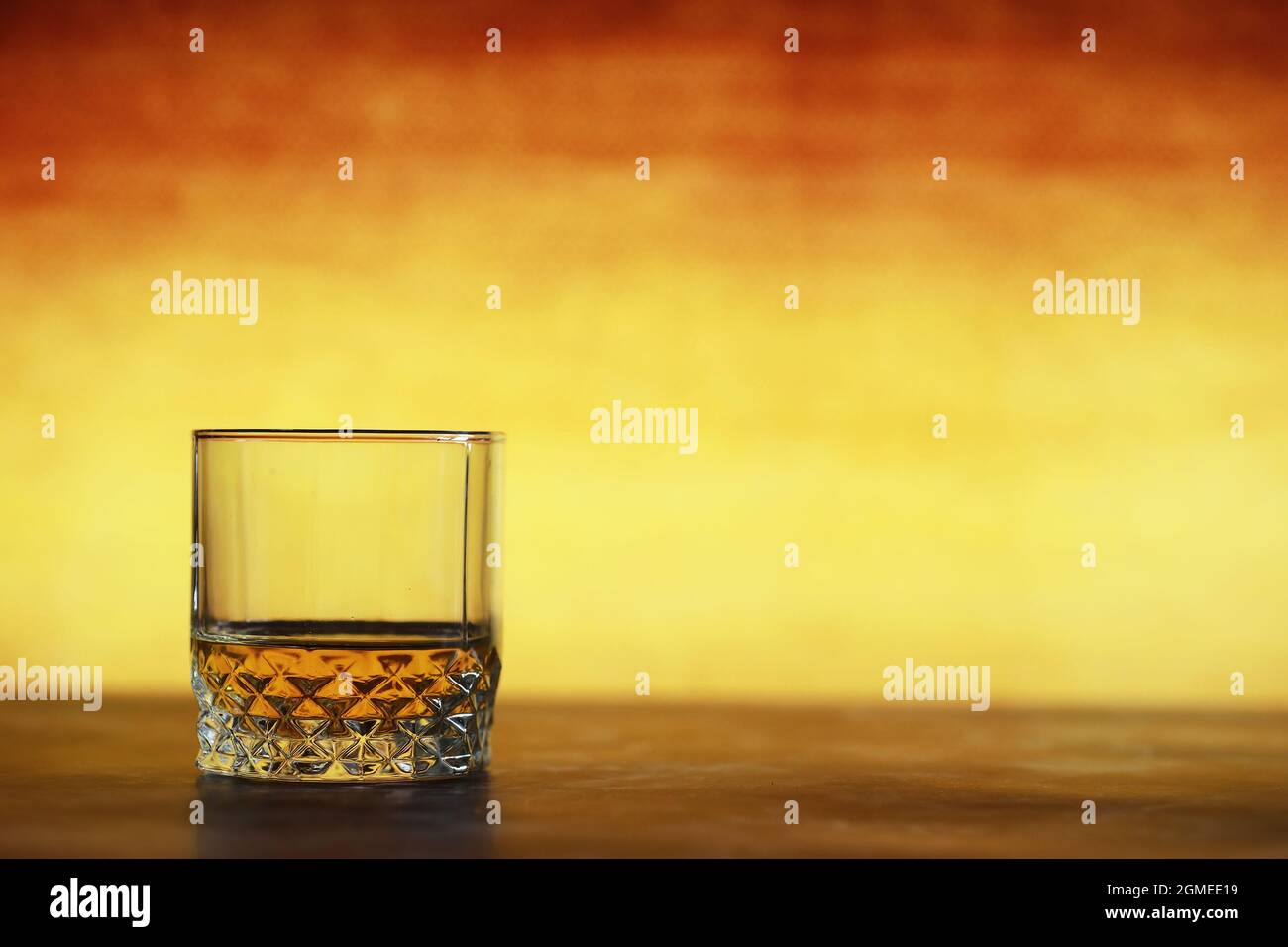 A glass of hard alcohol with ice on a bar counter. Whiskey with soda in ...