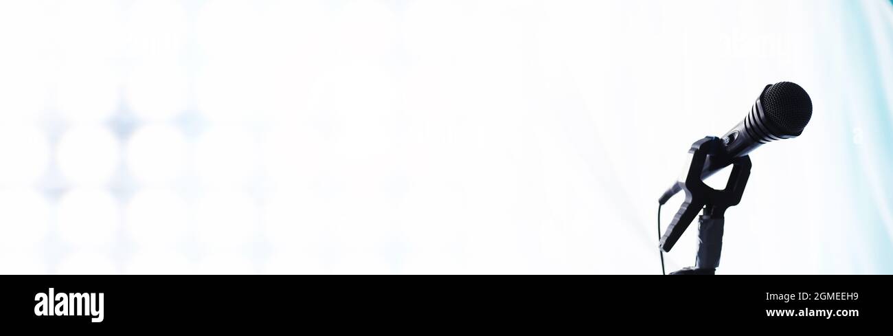 Stand with a microphone. Man holds hands a microphone on tripod ...