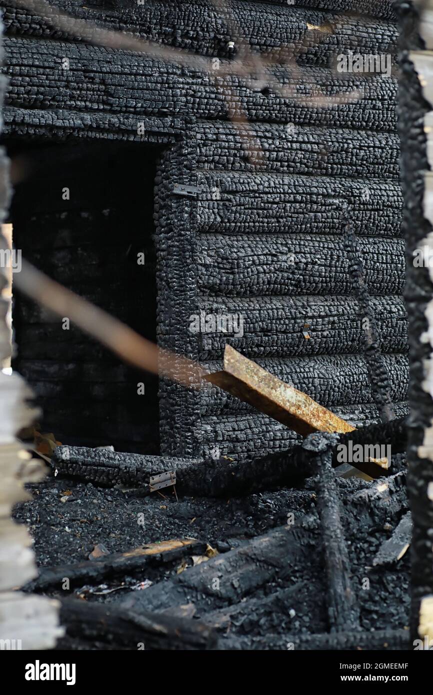 Wooden house after the fire. Coals on the logs. The ashes of the house ...